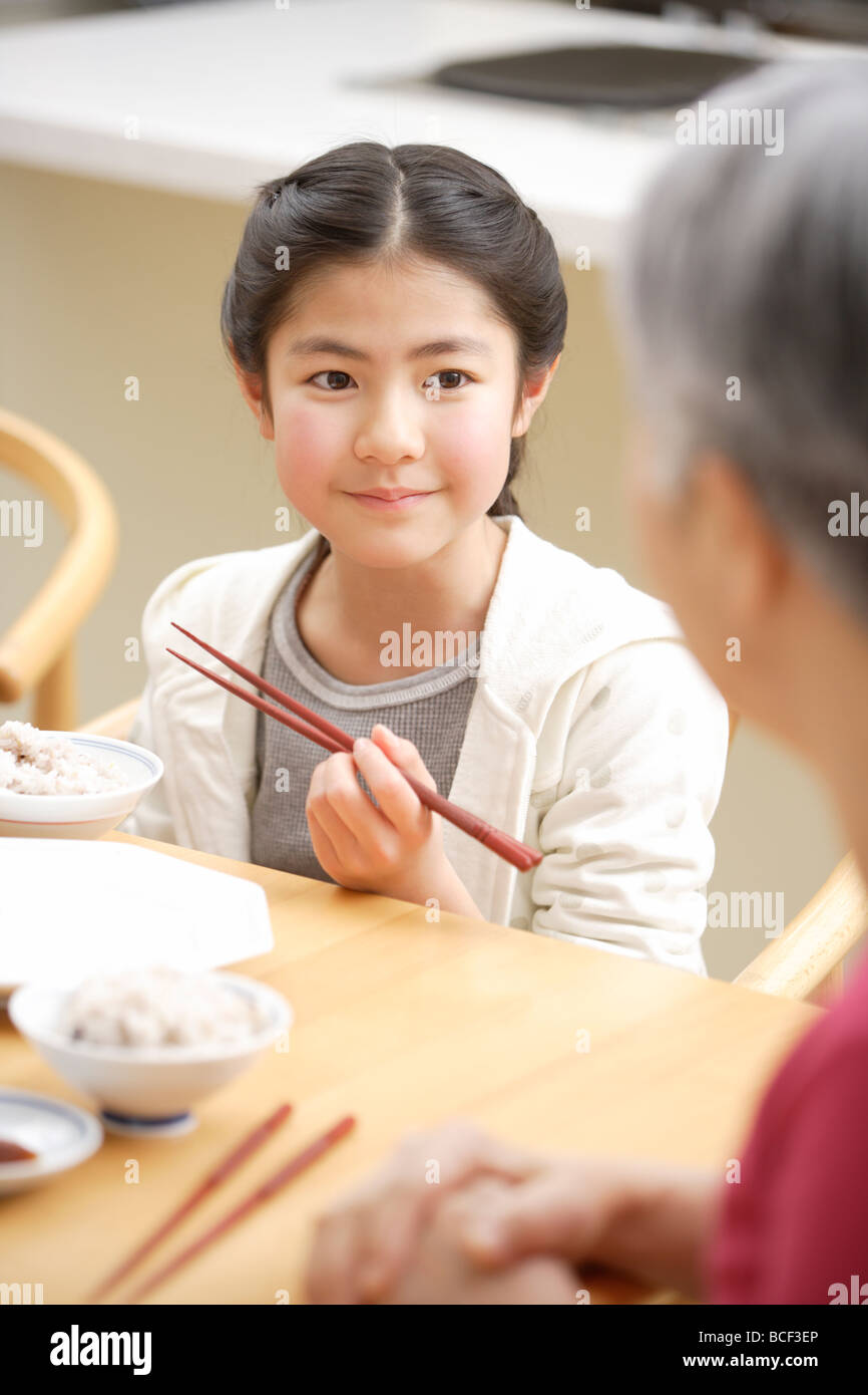 Girl eating at table Stock Photo - Alamy