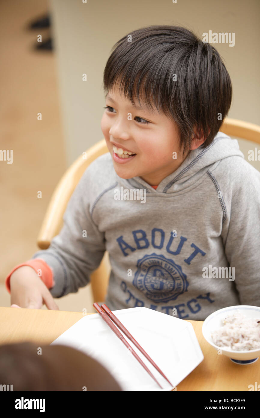 Boy eating at table Stock Photo - Alamy