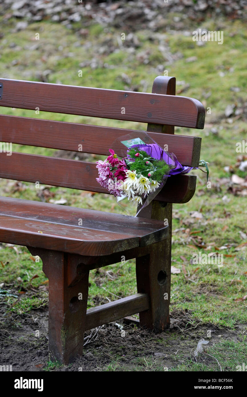 wooden outdoor park bench with bunch of flowers between slats Stock ...