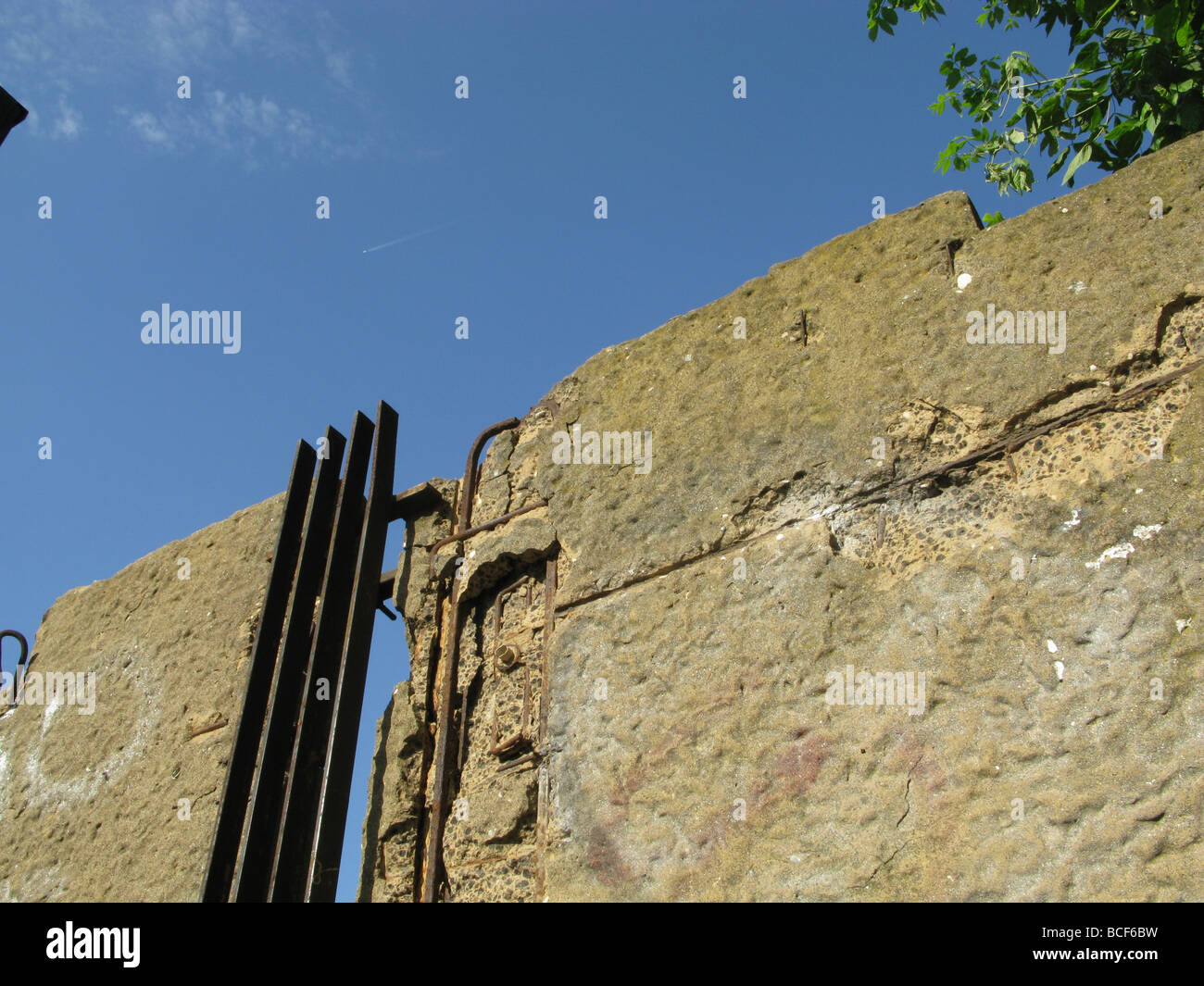 high stone wall with metal bars fitting and blue sky Stock Photo - Alamy