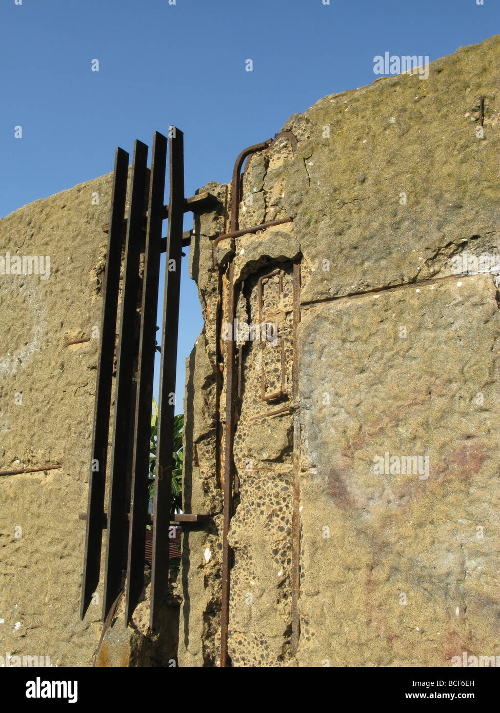 high stone wall with metal bars fitting and blue sky Stock Photo - Alamy
