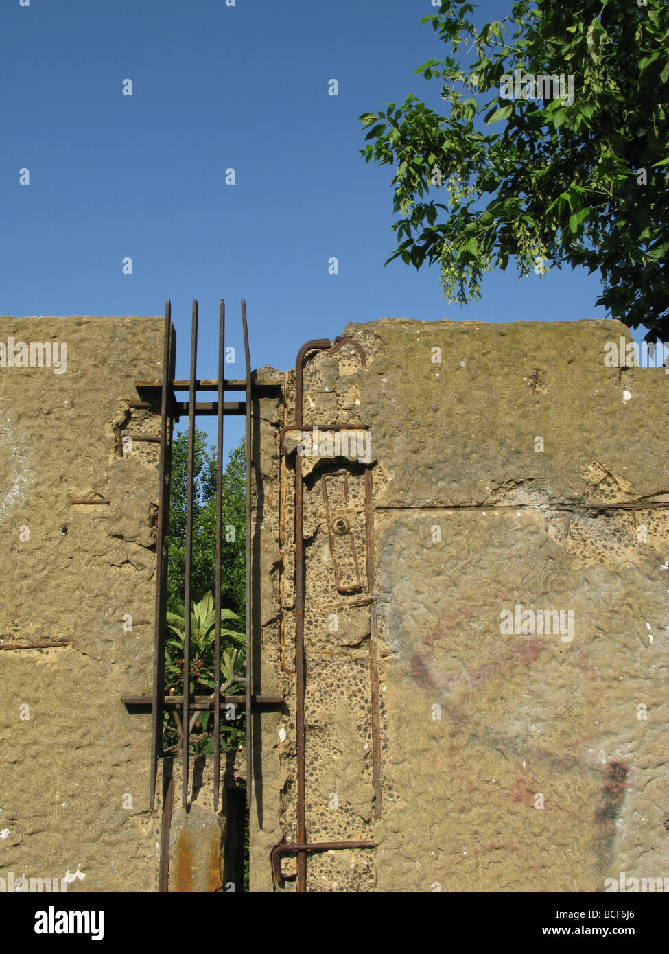 high stone wall with metal bars fitting and blue sky Stock Photo - Alamy