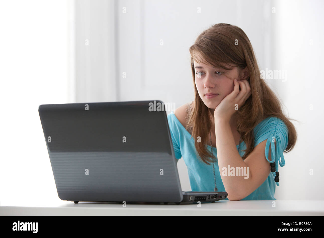 Teenage girl behind a laptop Stock Photo - Alamy