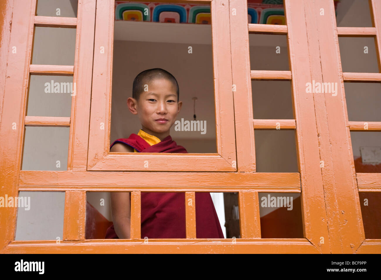 India, Sikkim, Gangtok, Lingdum Gompa, Novice monk looking through ...