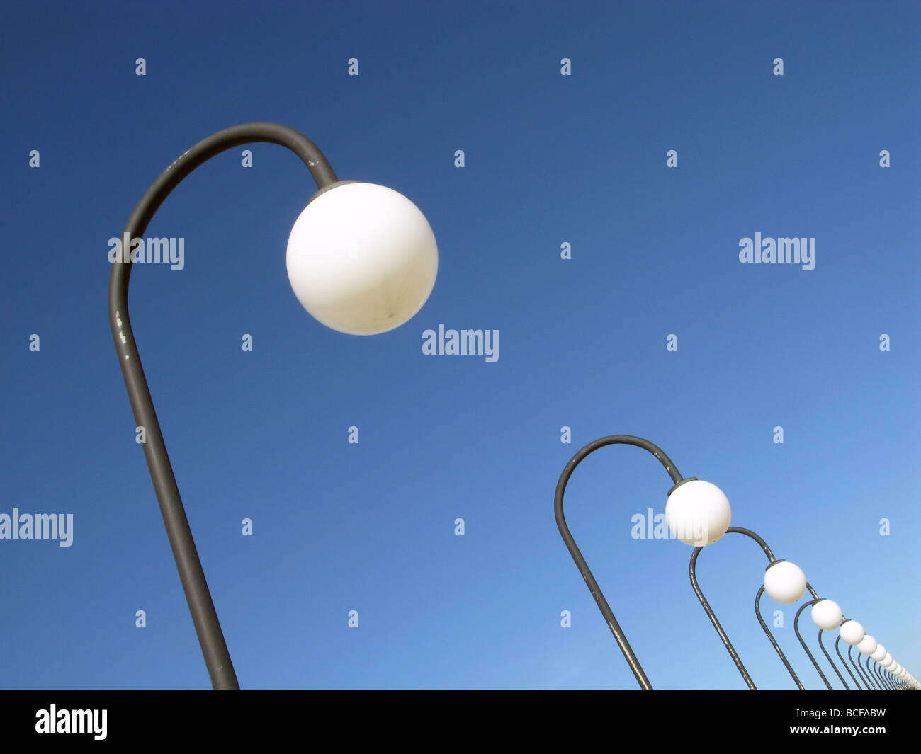 a long row line of street lights and blue sky Stock Photo - Alamy