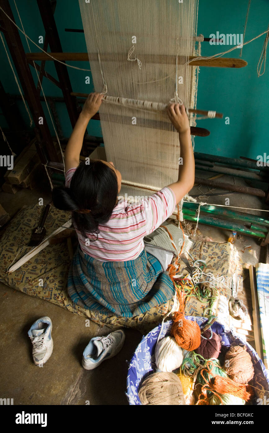 Woman carpet weaver works on a loom at the Tibetan Handicraft Center ...