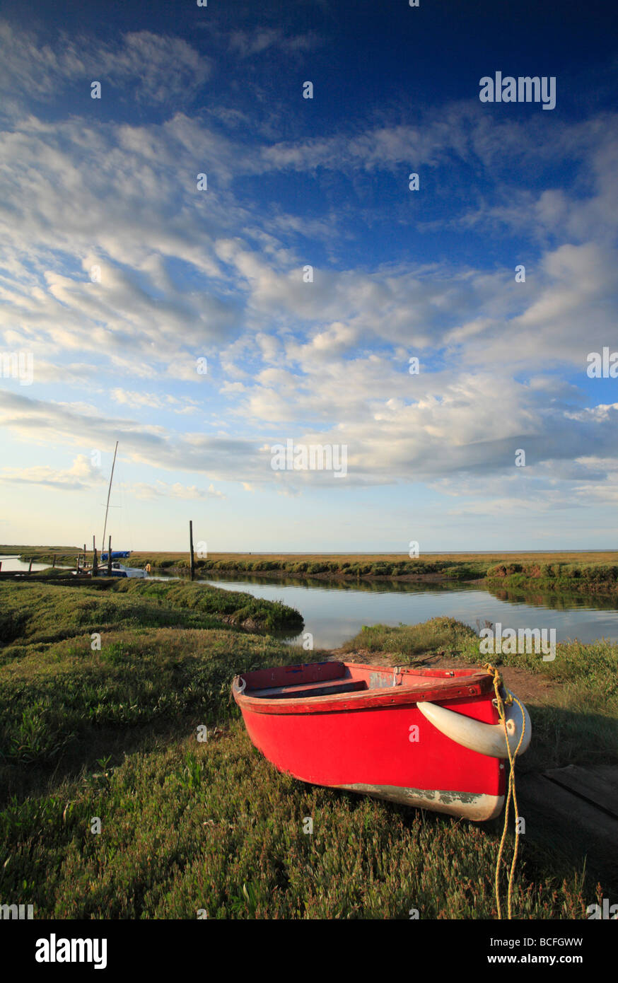 A red rowing boat resting on the marsh at Thornham on the North Norfolk ...