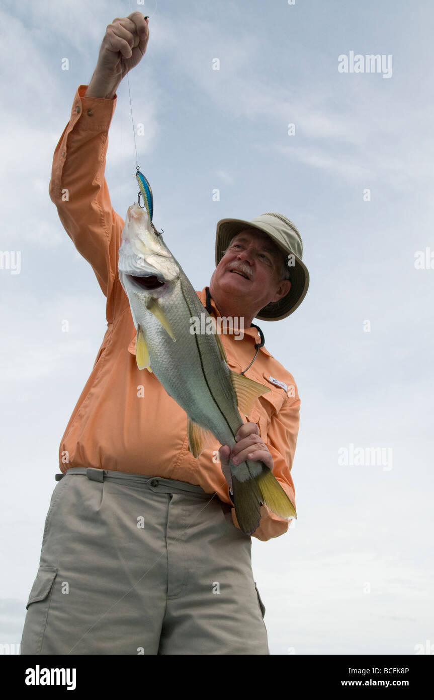 An angler fishing the river mouth in Belize lifts a nice snook prior to ...