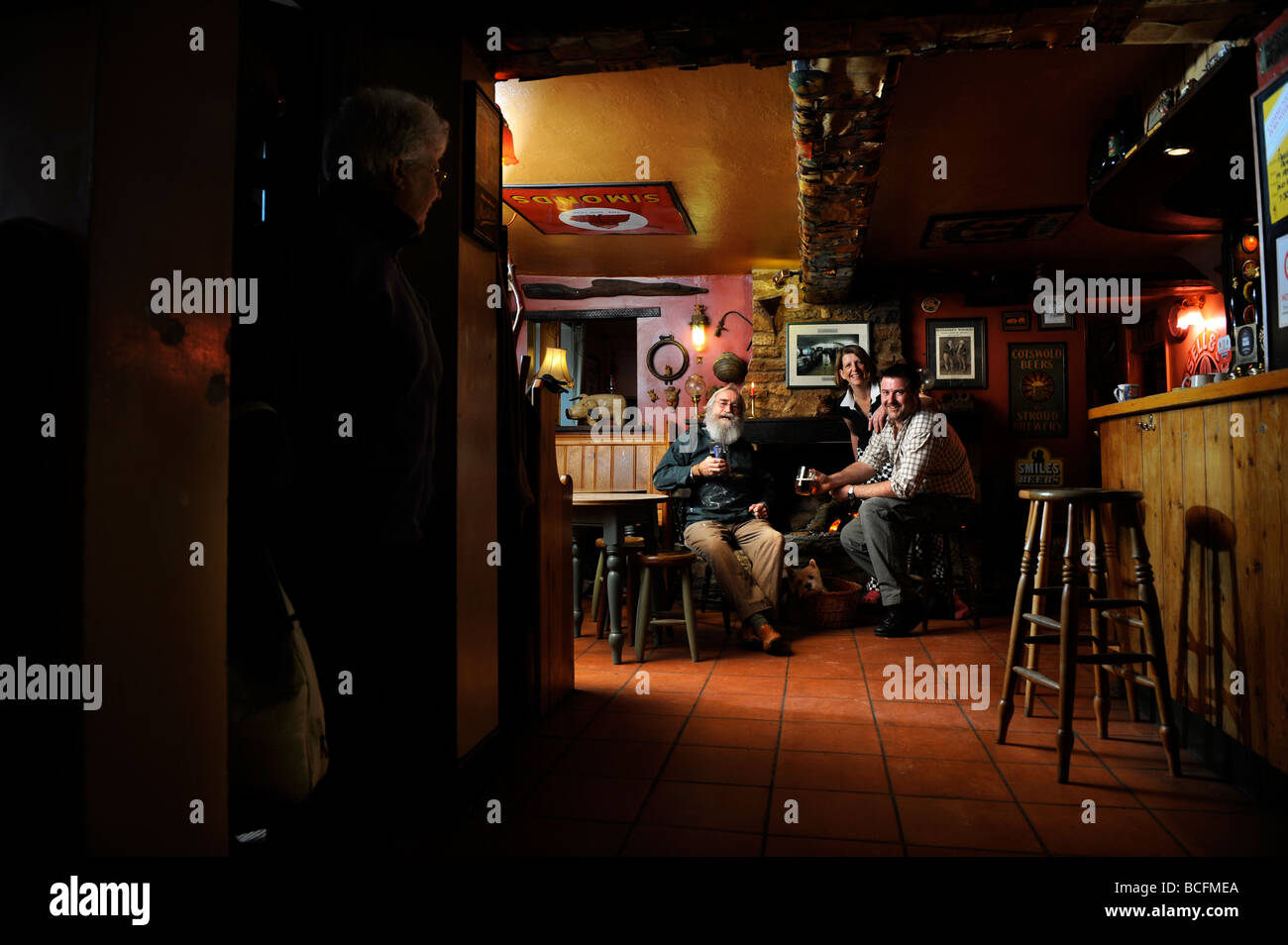 GROUP BY AN OPEN FIRE IN A TRADITIONAL PUB WITH A CUSTOMER IN THE ...