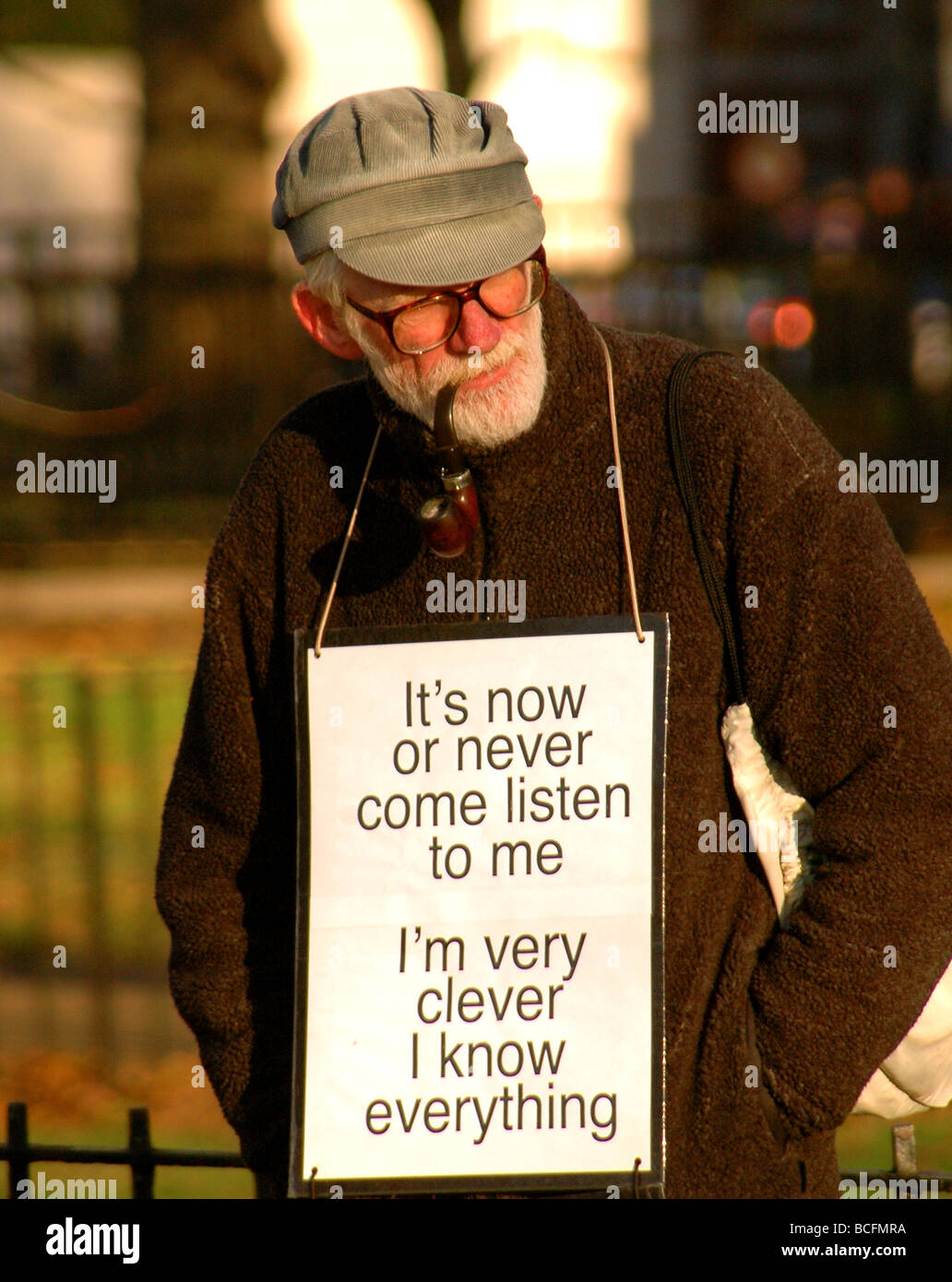English man stand in the park with funny placard hanging on his neck ...