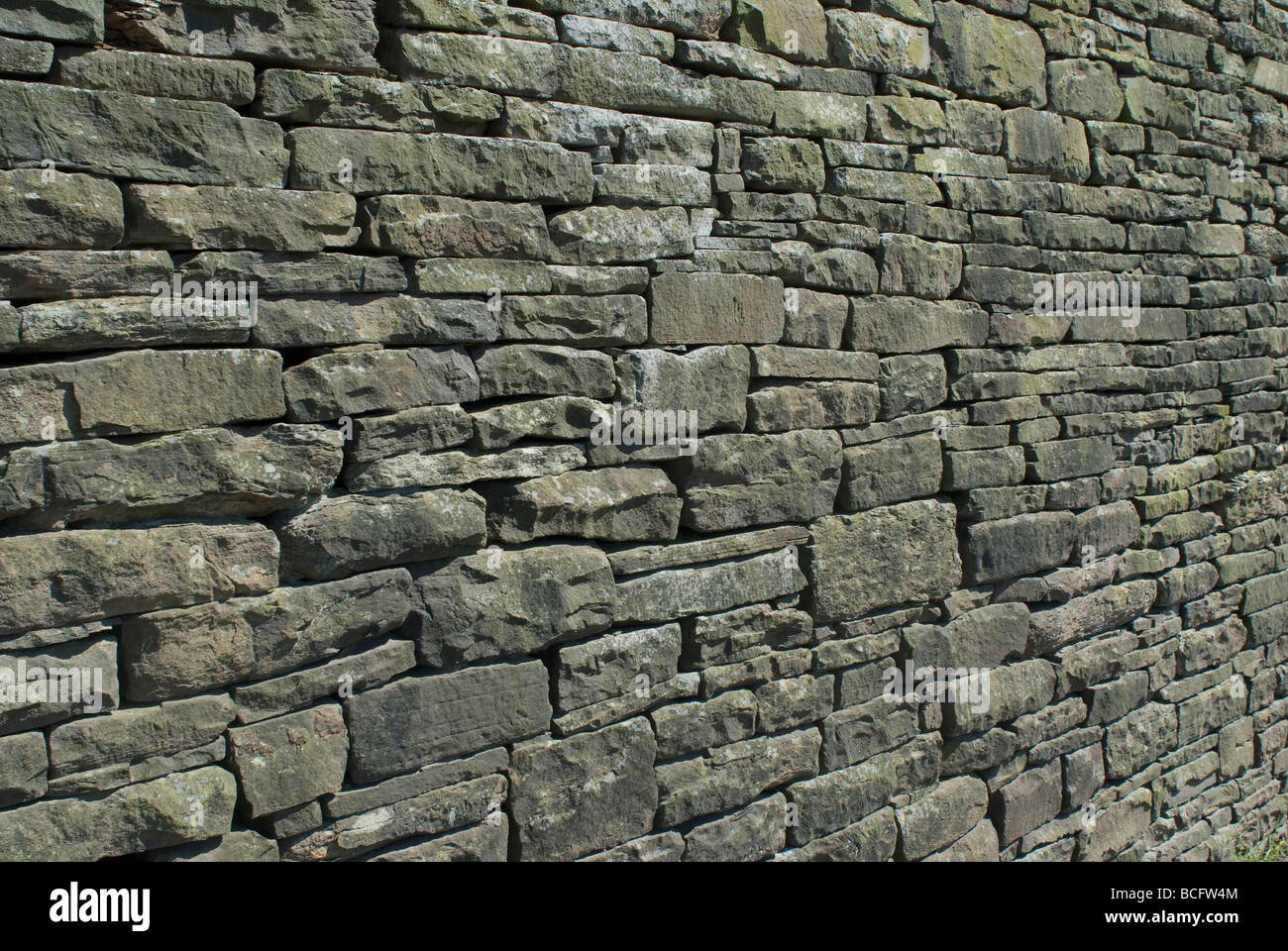 A brick wall made of natural stone and at an oblique angle Stock Photo ...