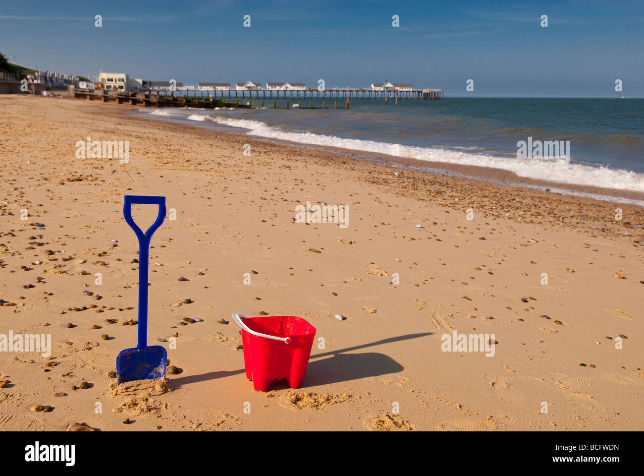 A bucket and spade on the beach at Southwold Suffolk Uk with pier ...