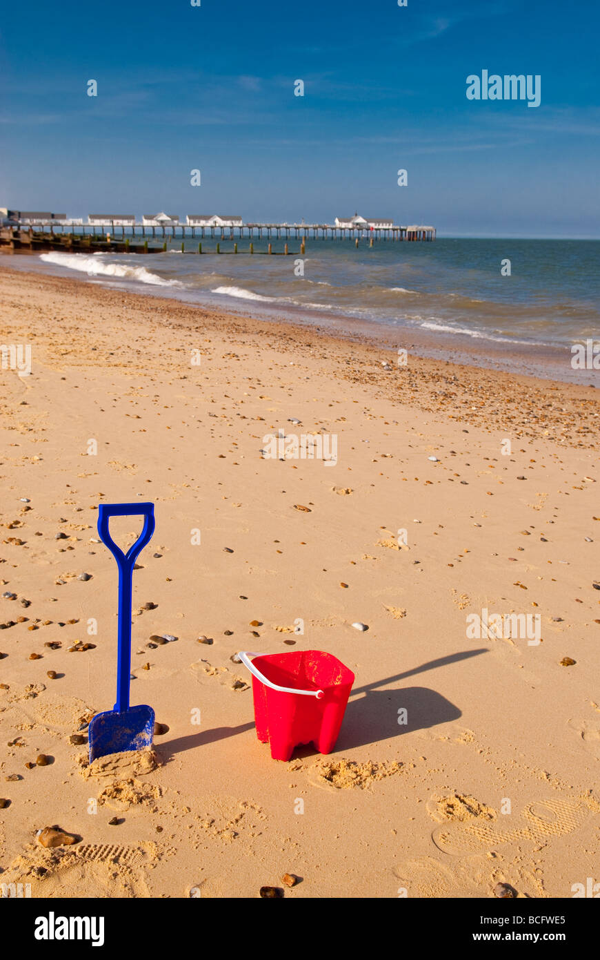 A bucket and spade on the beach at Southwold Suffolk Uk with pier ...