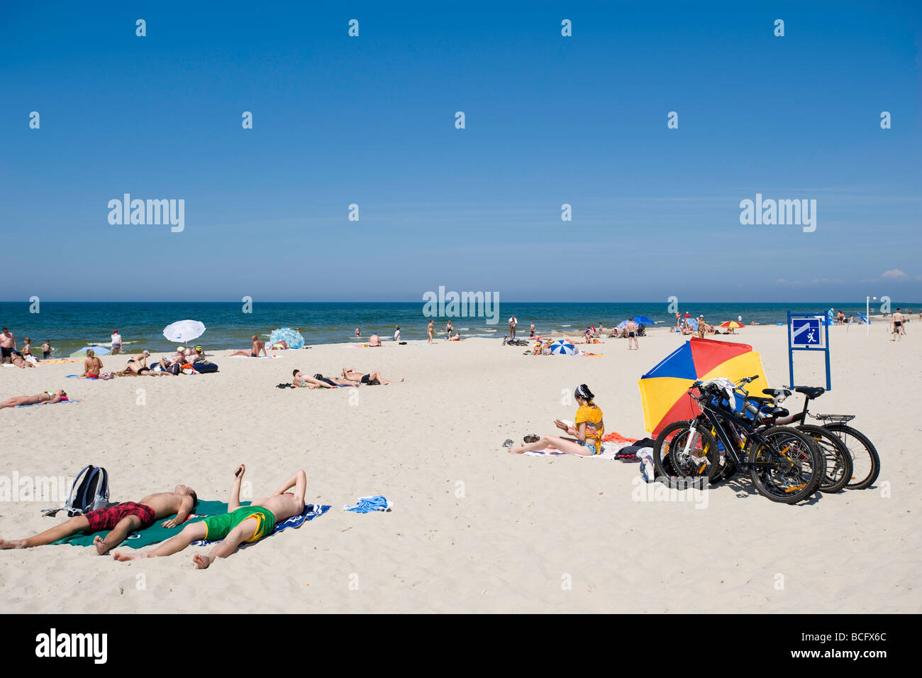 People enjoy hot summer day on sandy beach Baltic Sea Nida village ...