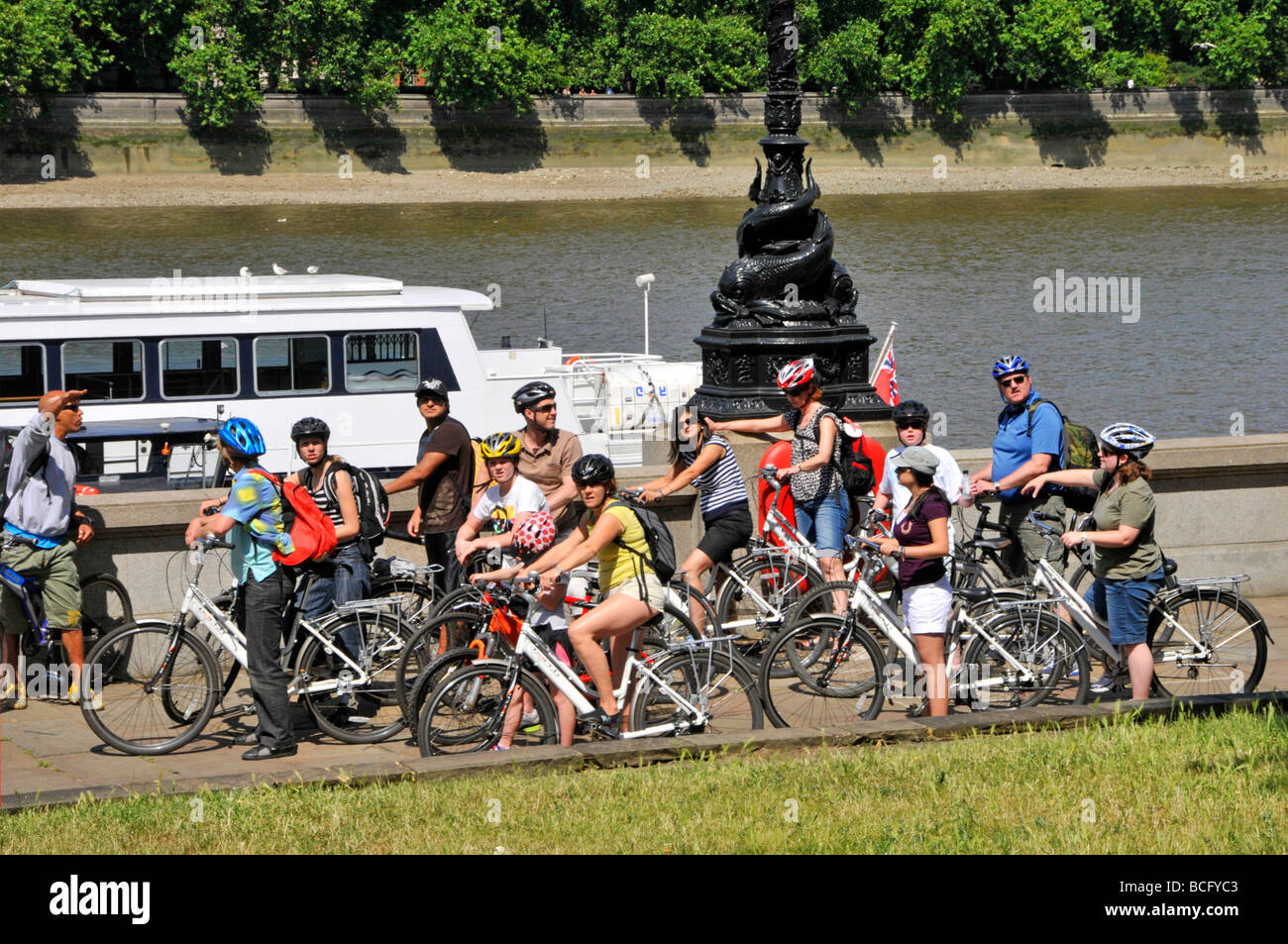 Group of cyclists on escorted sightseeing tour beside River Thames at ...