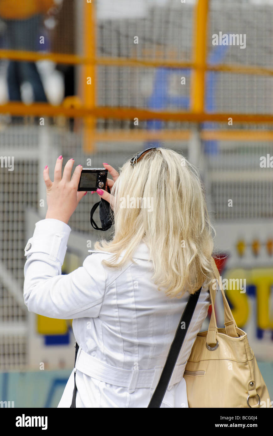 Young woman in white takes a photo with compact camera Stock Photo - Alamy