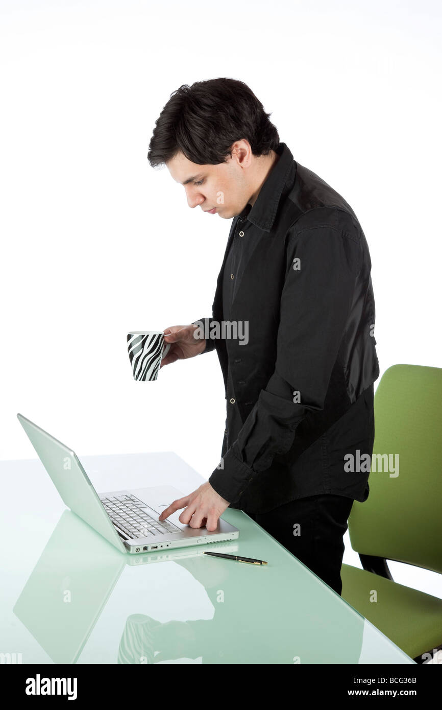 Latino man standing and working at a laptop Stock Photo - Alamy