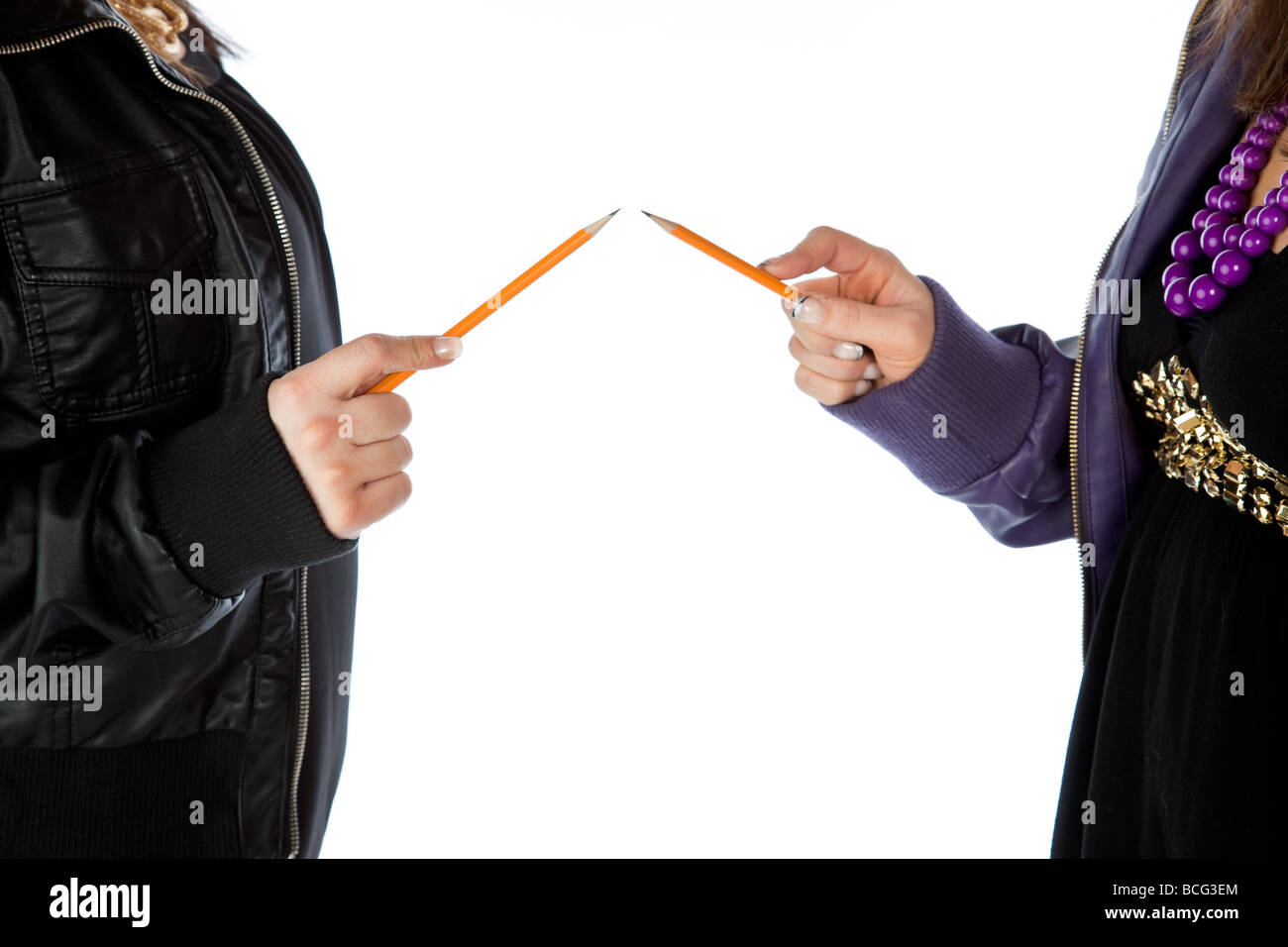 Holding pencils pointing at each other isolated against white Stock ...