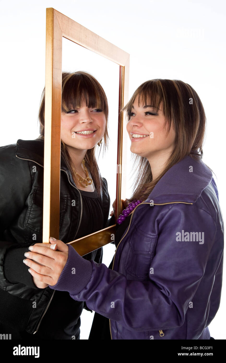 Twin girls holding a picture frame isolated against white Stock Photo ...