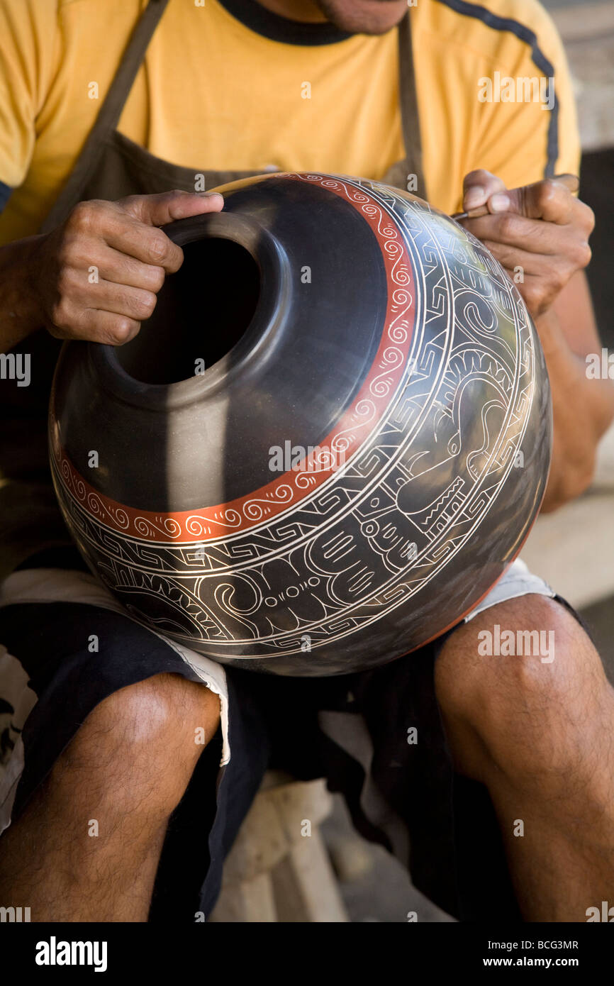 An artisan works on a piece of pottery in Guaitil which is in ...
