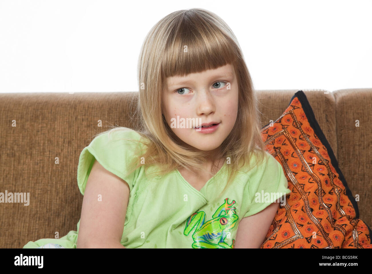 Pretty young girl siting on a sofa Stock Photo - Alamy