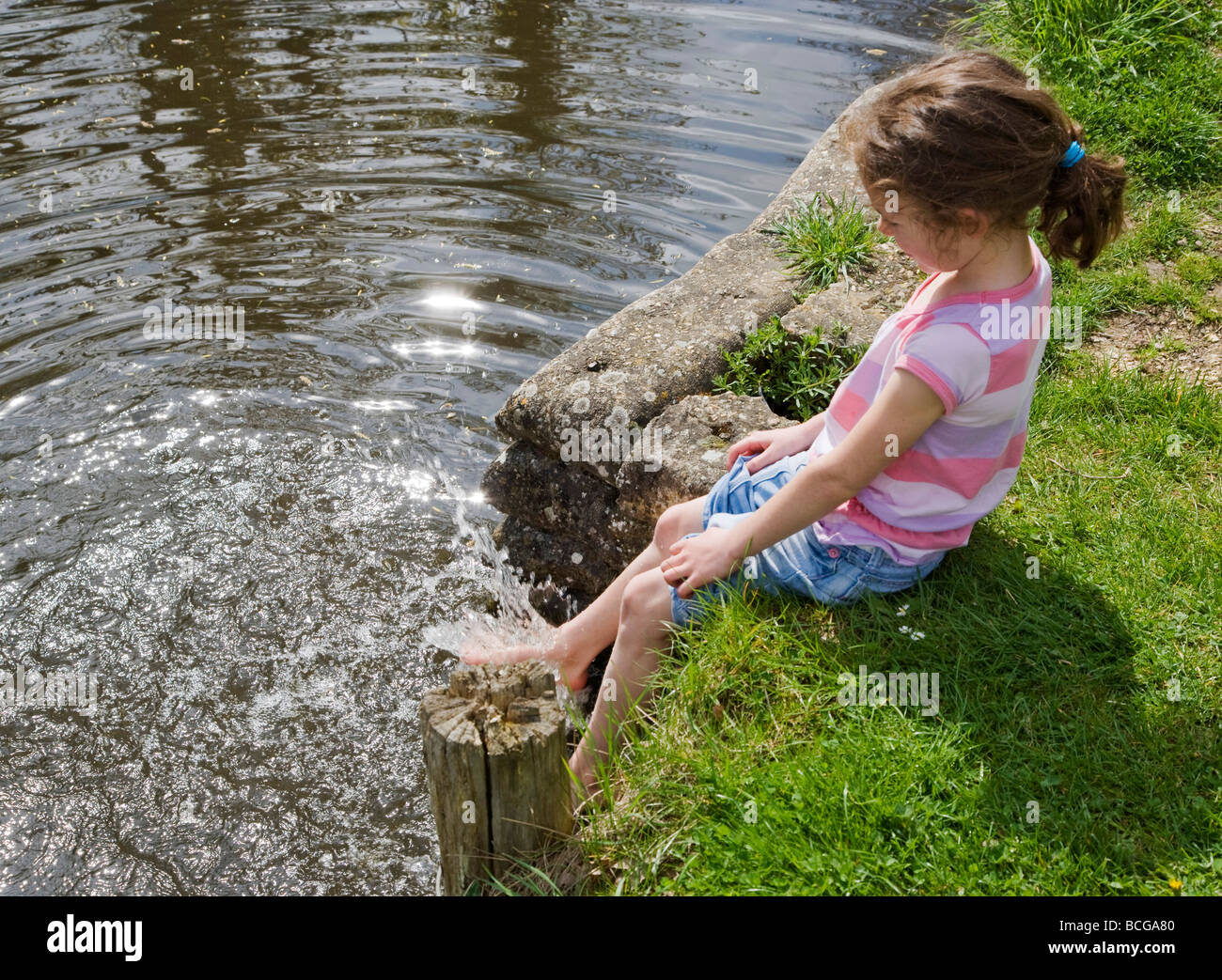 Child Splashing in a Village Pond Stock Photo - Alamy