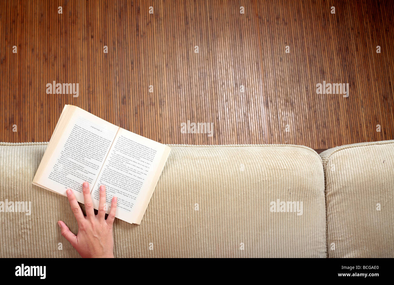 Woman on a sofa reading a book Stock Photo - Alamy