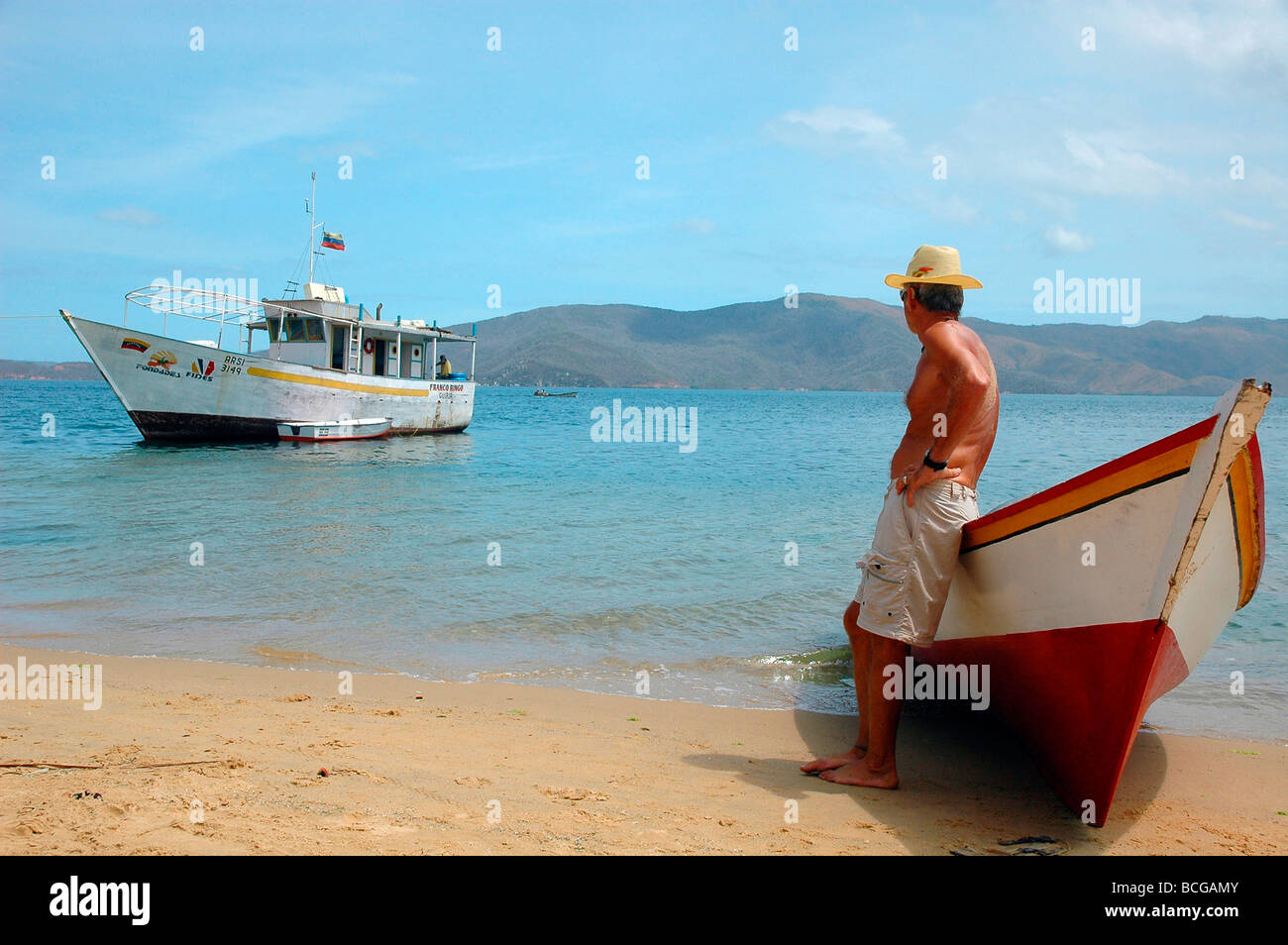 A local sailor watches his boat Stock Photo - Alamy