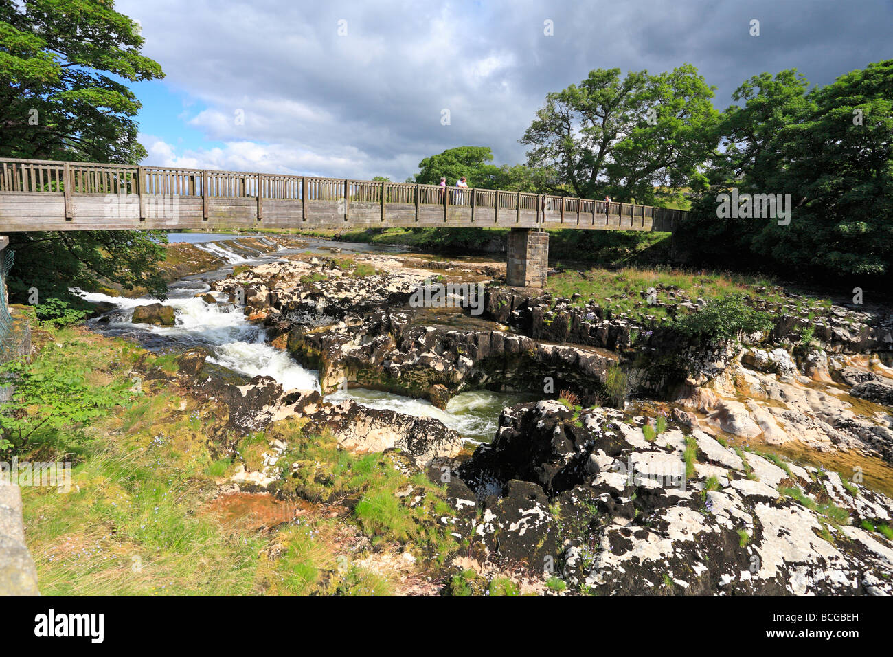 Wooden footbridge over Linton Falls, River Wharfe near Grassington ...