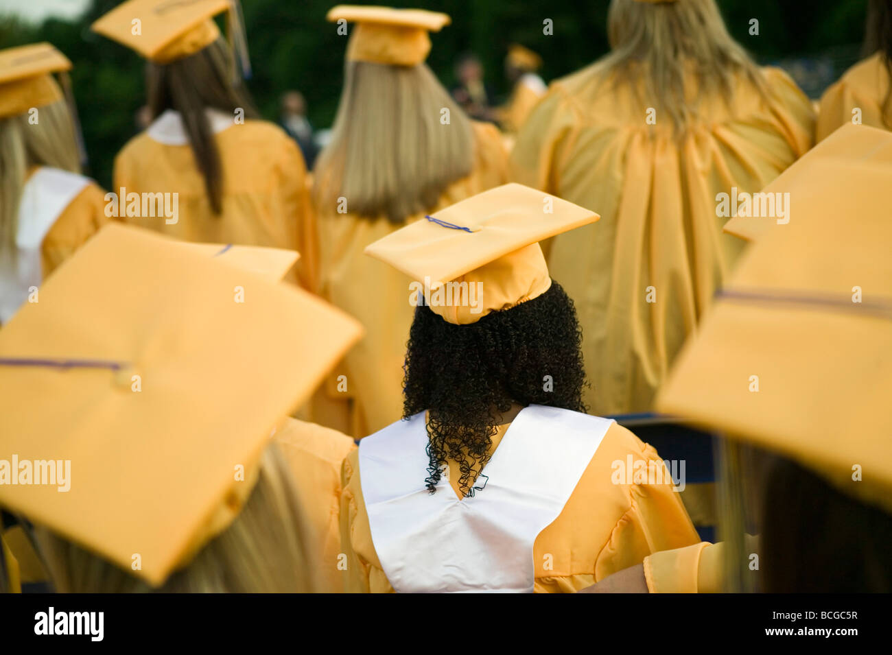 High School students wearing gold cap and gown attend Graduation ...