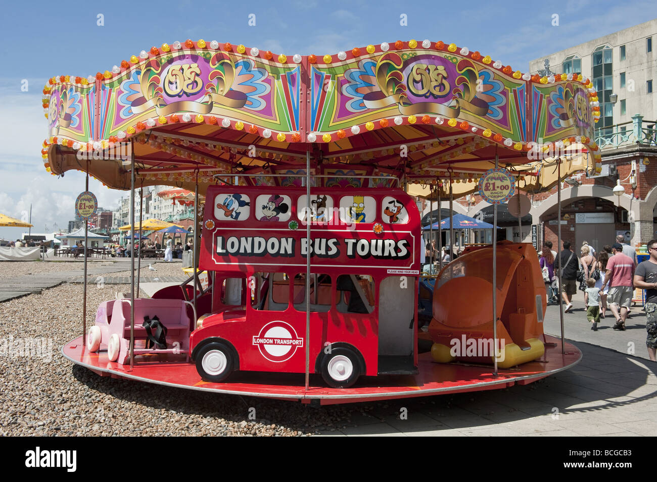 Childrens roundabout carousel ride on seaside promenade featuring mini ...