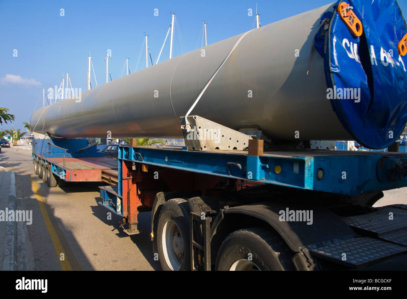 Wind turbine mast being transported on lorry by road through Agia ...