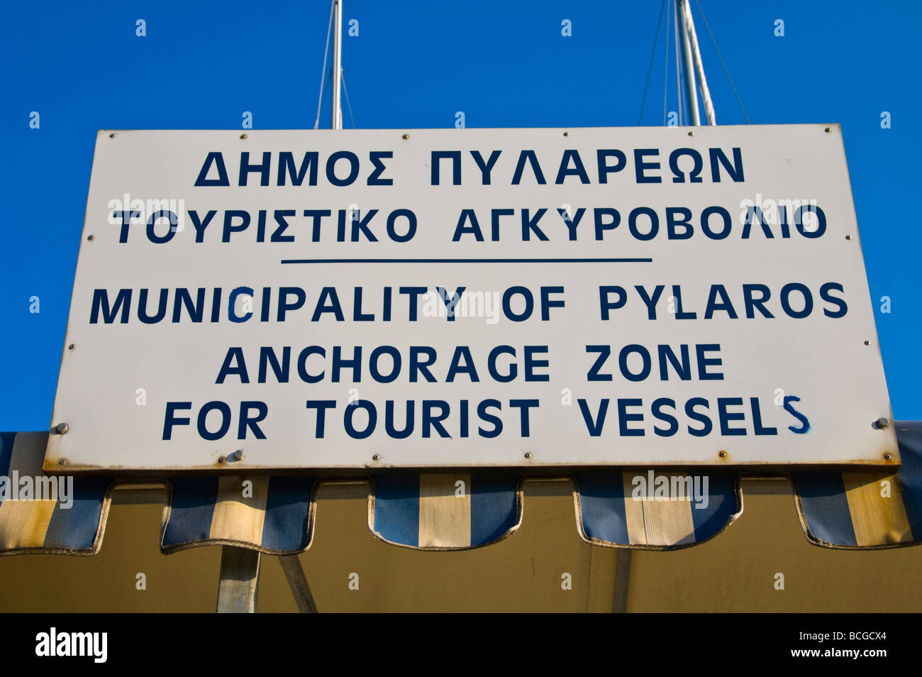Bilingual Greek English sign for tourist vessels in small harbour at ...