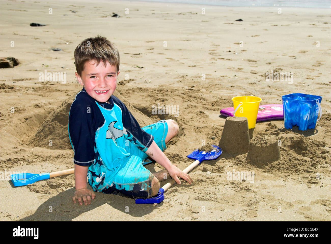 Boy playing with bucket and spade in the sand hi-res stock photography ...