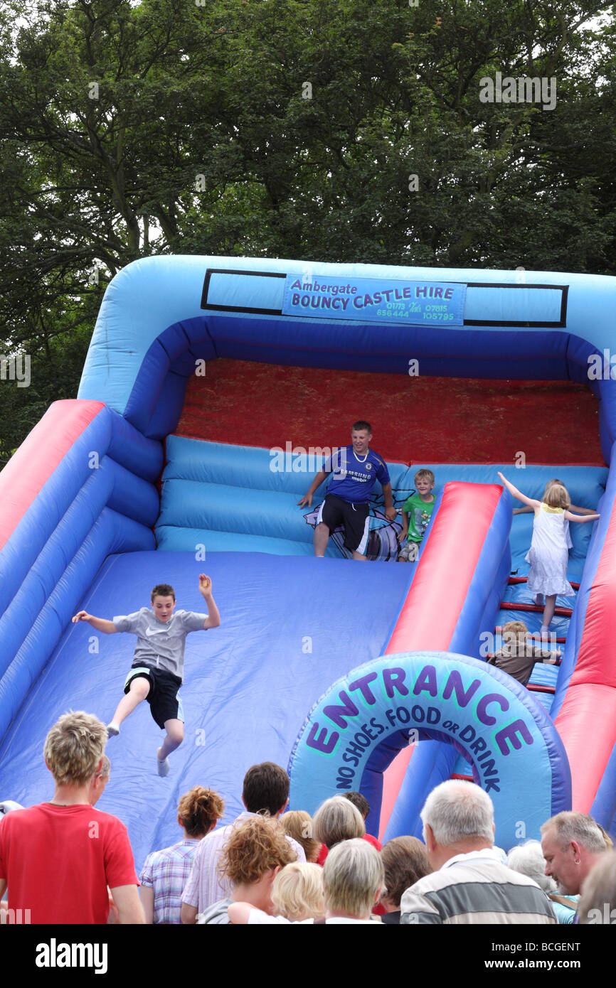 Children on an inflatable slide at an English village show. Ambergate ...