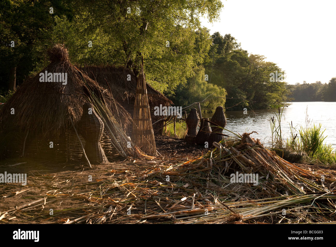 Primative living in stick and reed huts by a lake Stock Photo - Alamy