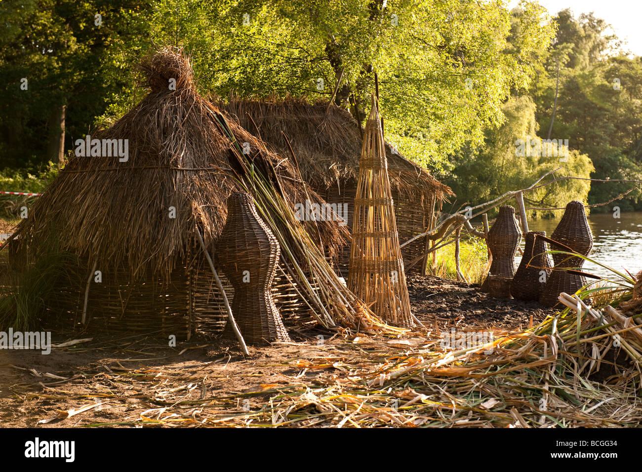 Primative living in stick and reed huts by a lake Stock Photo - Alamy