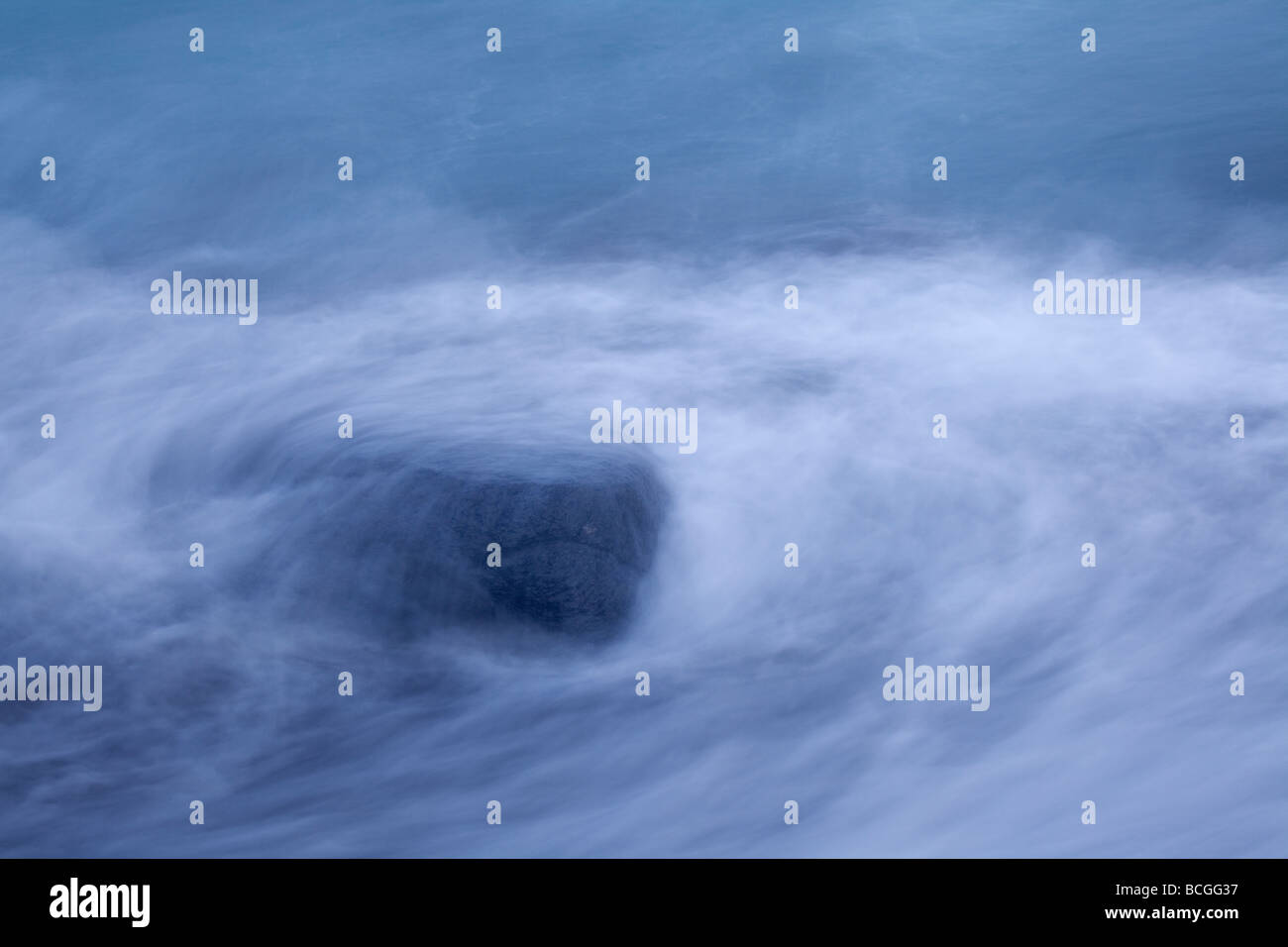 Sea swirling around rocks on the beach with the rising tide Stock Photo ...