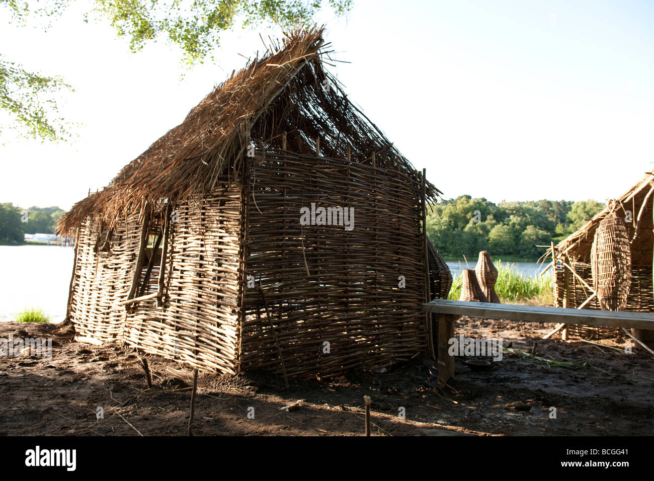 Primative living in stick and reed huts by a lake Stock Photo - Alamy