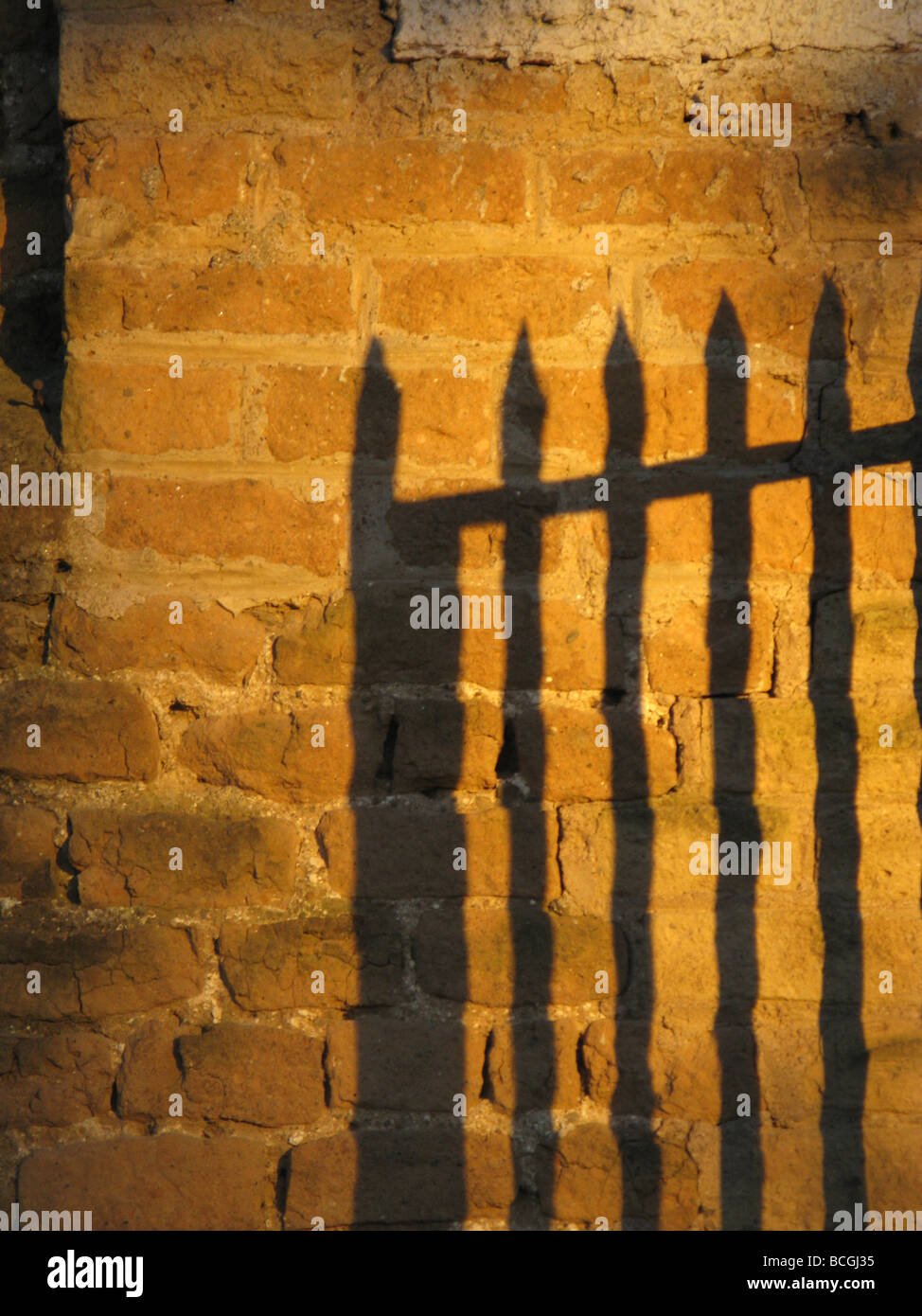 metal fence shadow on orange brick wall Stock Photo - Alamy