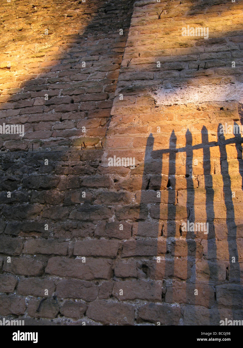 metal fence shadow on orange brick wall Stock Photo - Alamy
