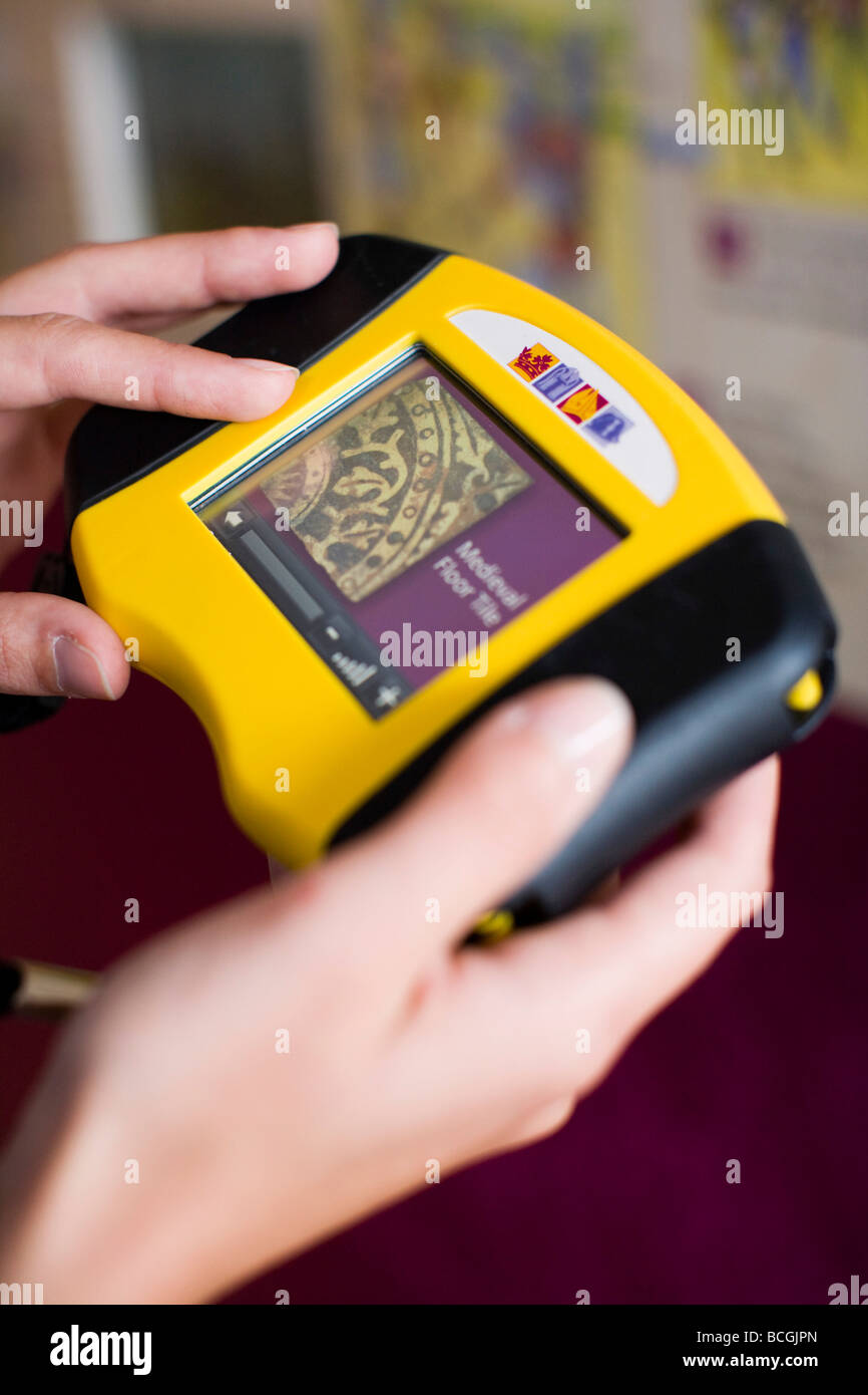 Woman using an interactive handheld museum guide, UK Stock Photo - Alamy