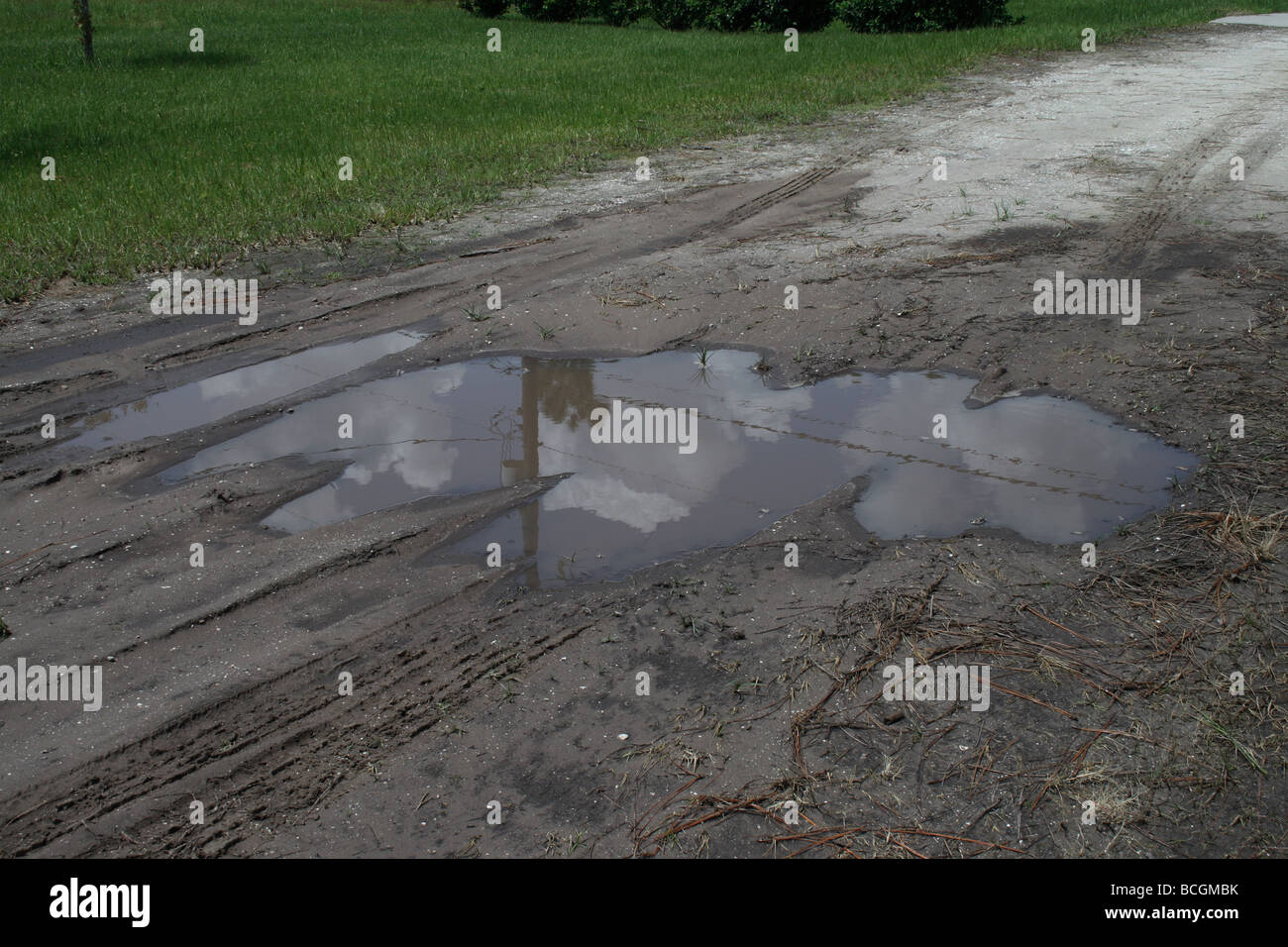 Puddle in dirt driveway Stock Photo - Alamy