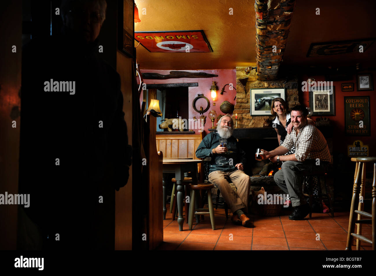 GROUP BY AN OPEN FIRE IN A TRADITIONAL PUB WITH A CUSTOMER IN THE ...