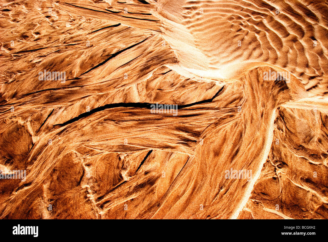Patterns created by sea water tide and wind on an Atlantic coast beach ...