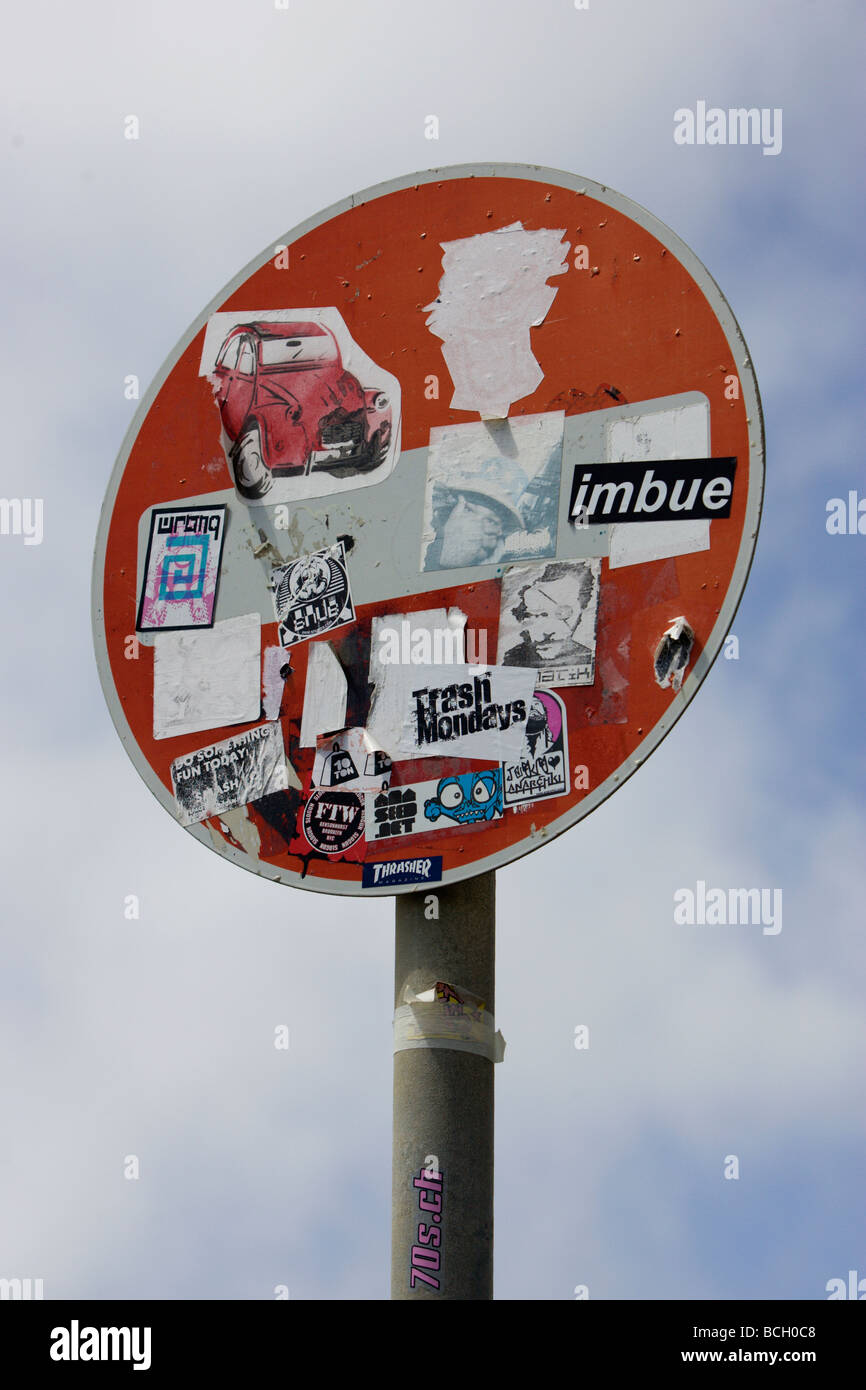No entry road sign covered with old and colourful stickers and graffiti ...
