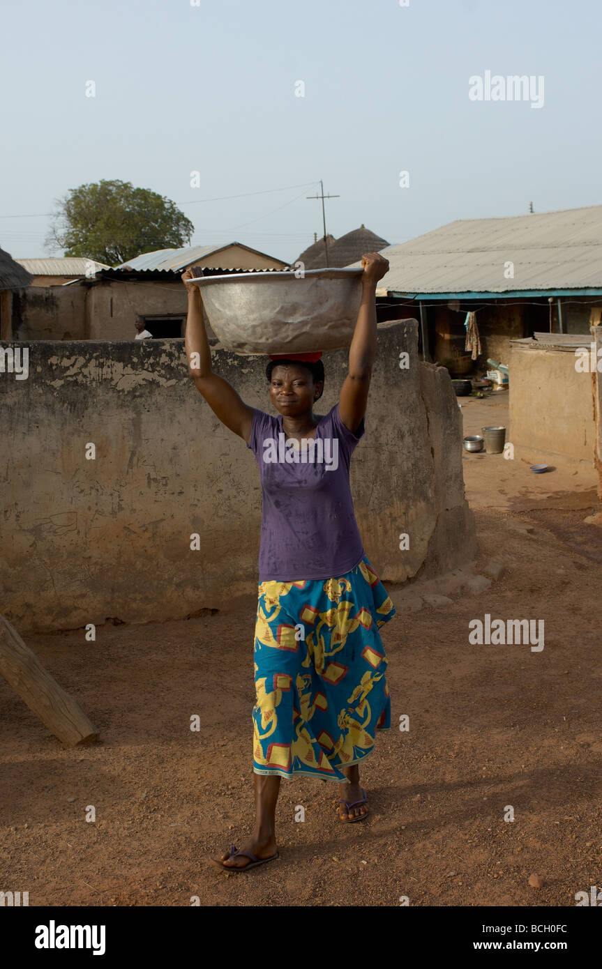 Women collecting water from water hole on heads in village in Tamale ...