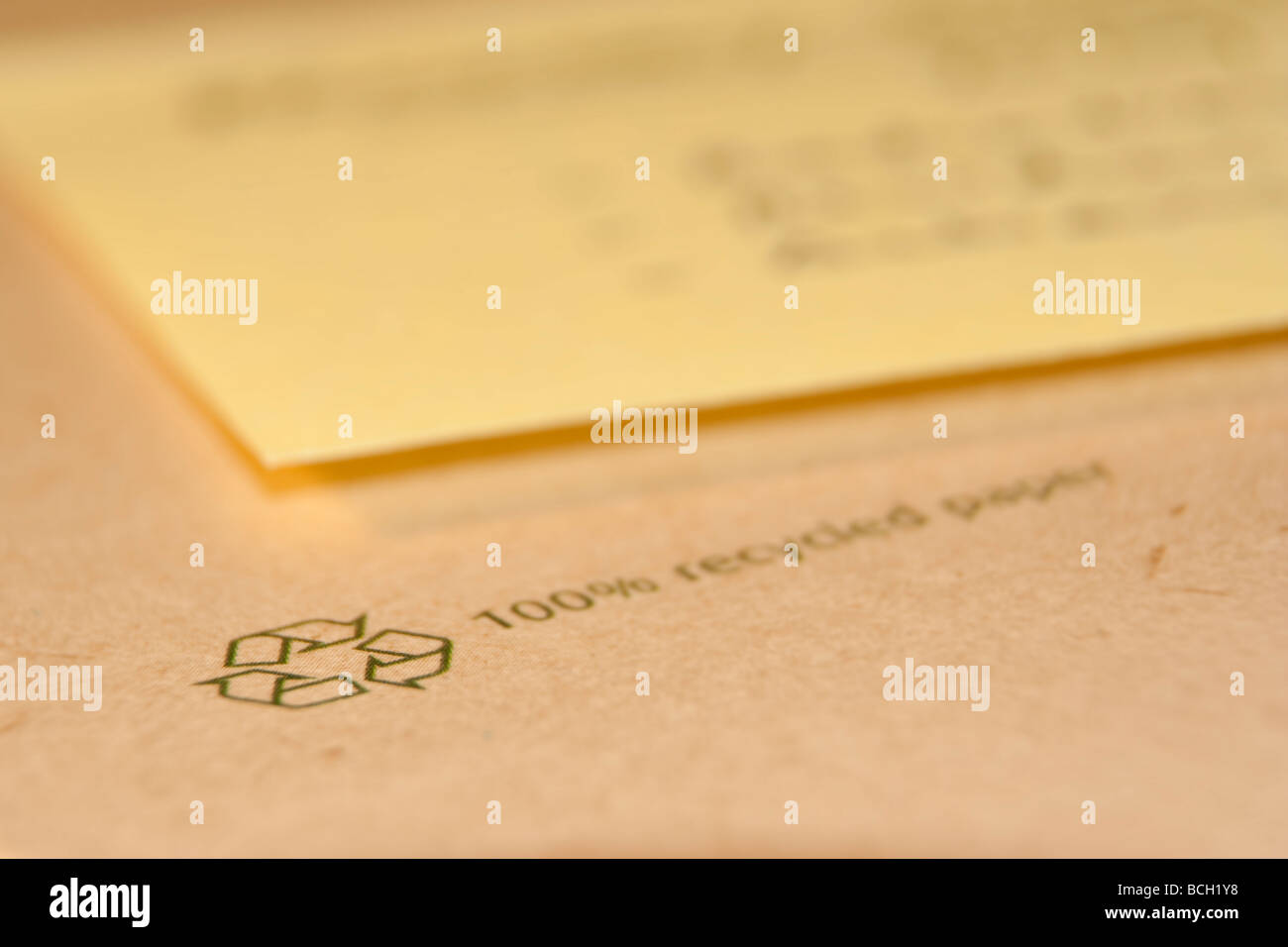 Yellow note over Recycled Paper Stock Photo - Alamy