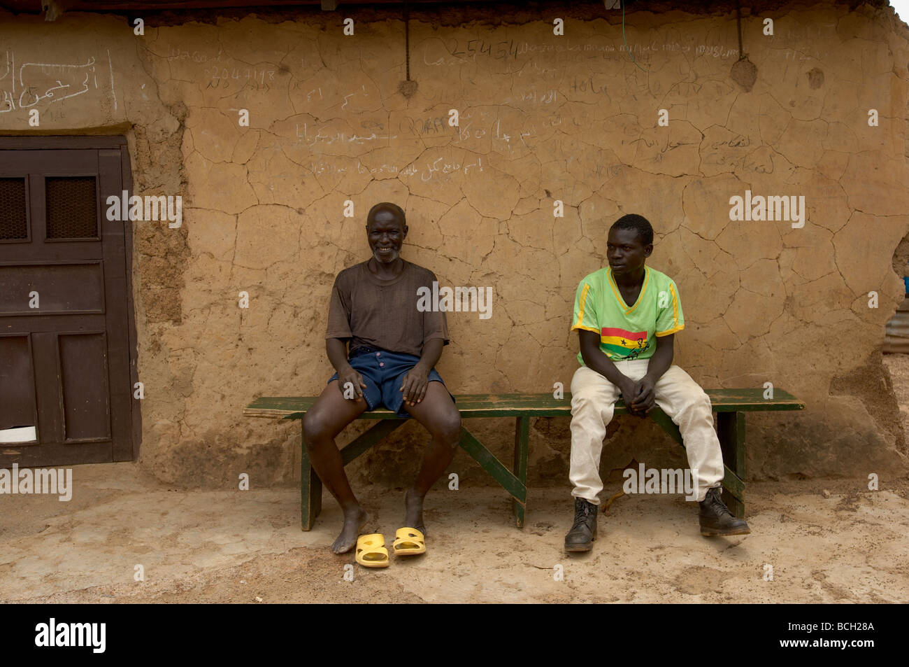Two men sitting on bench in village Tamale Ghana Stock Photo - Alamy