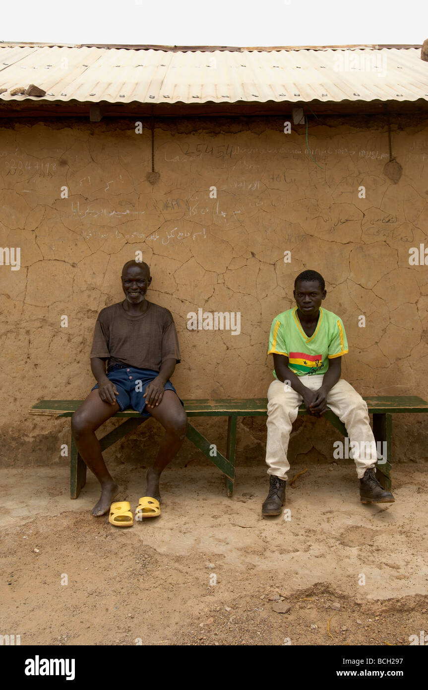 Two men sitting on bench in village Tamale Ghana Stock Photo - Alamy